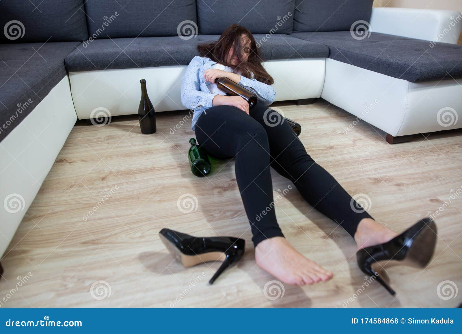 Drunk Woman Laying On The Floor After Huge Party With Some Bottles Of