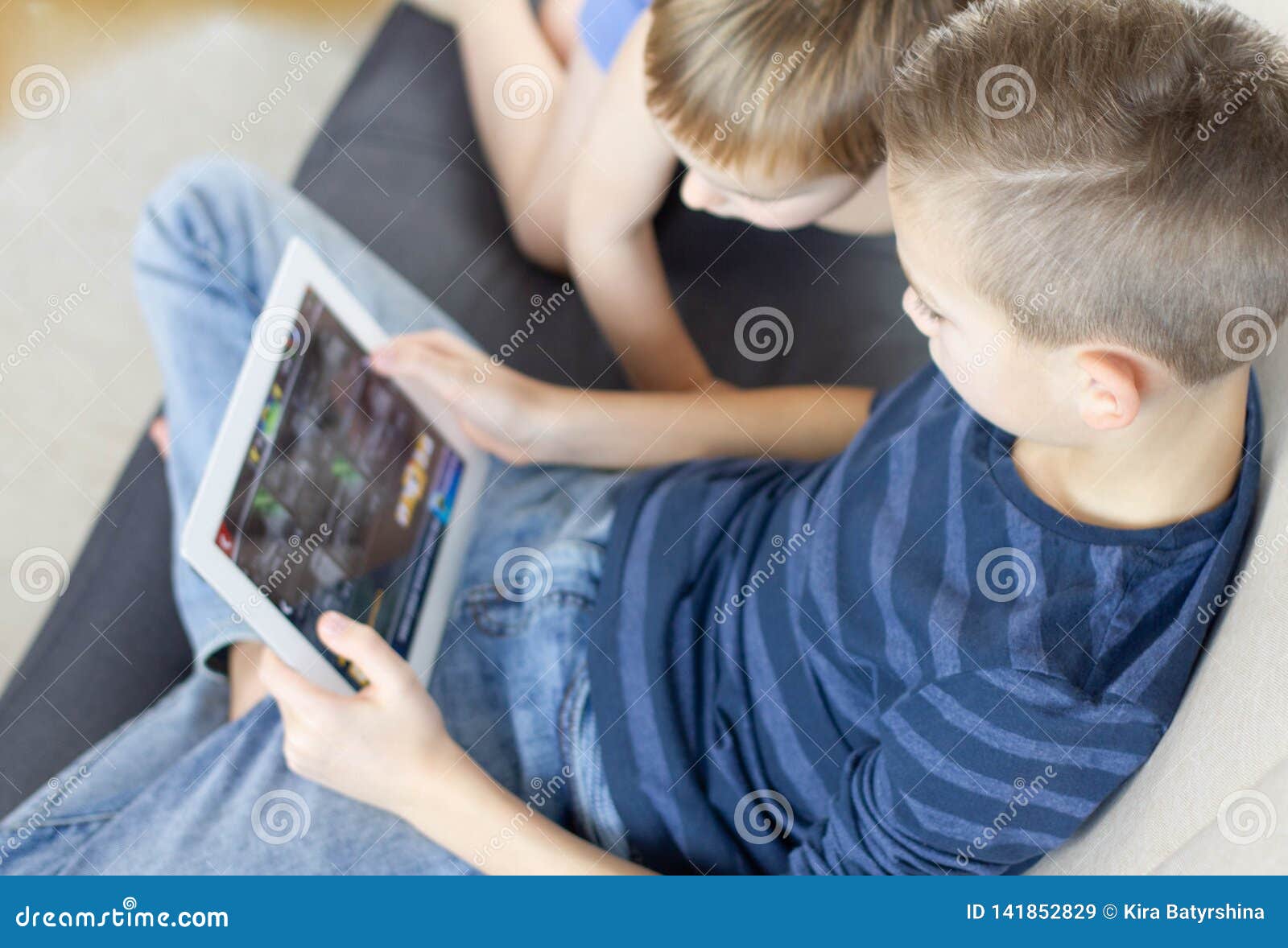 Duas Crianças Que Usam A Tabuleta Em Casa Irmãos Com O Tablet Pc Na