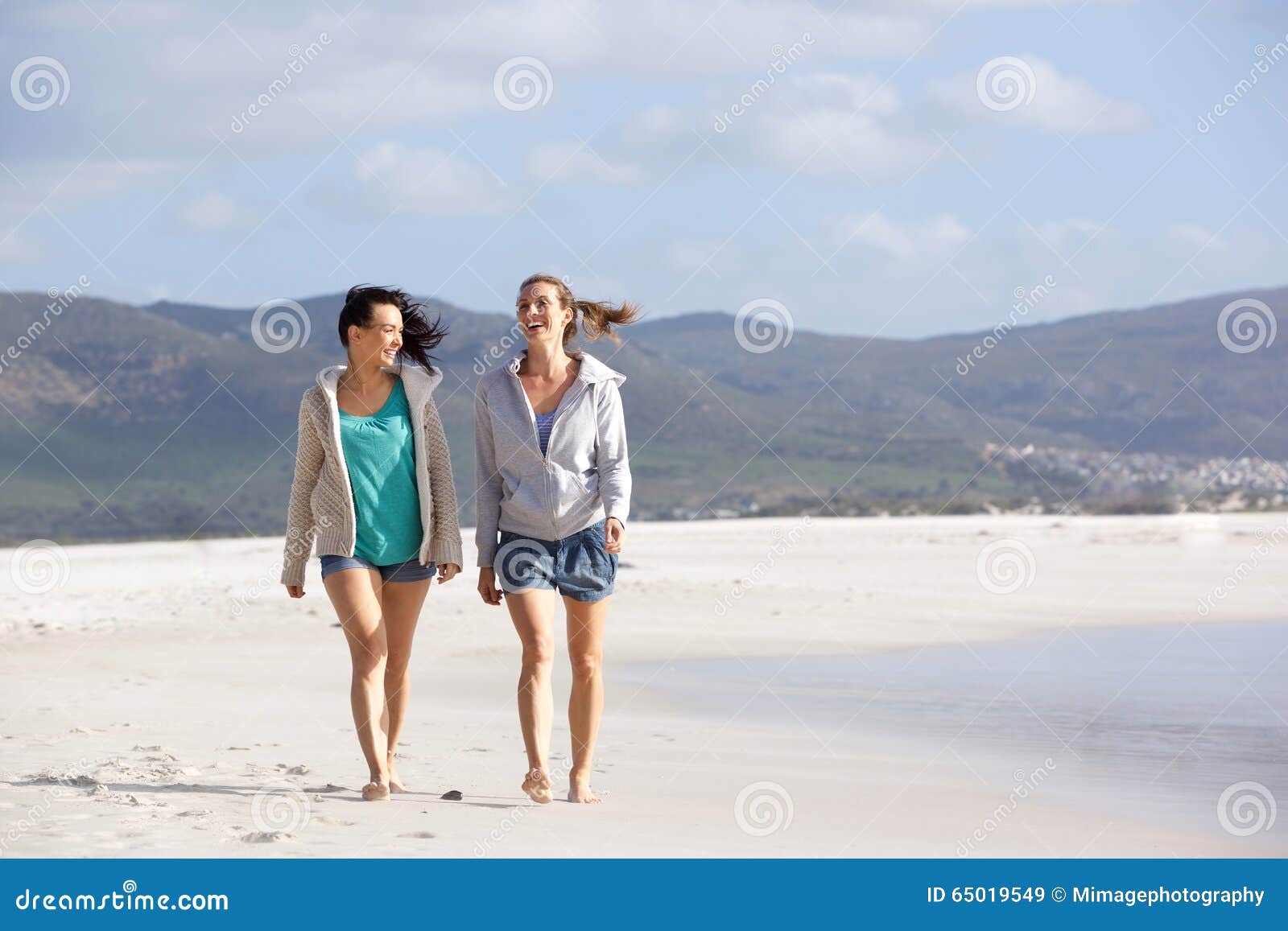 Due Amiche Che Camminano E Che Parlano Sulla Spiaggia Immagine Stock ...