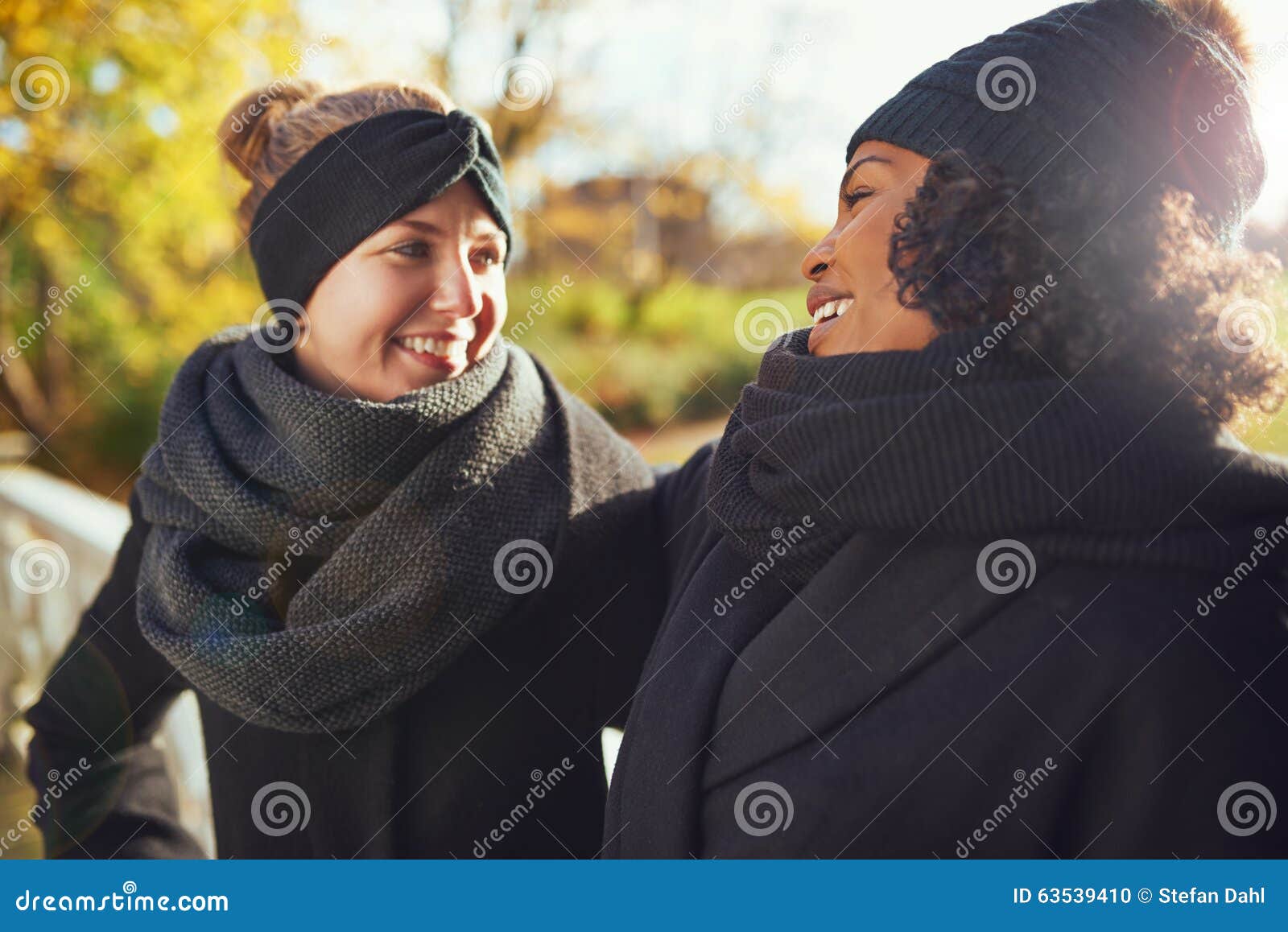 Due Amiche Che Si Esaminano Reciprocamente E Sorridere Fotografia Stock ...