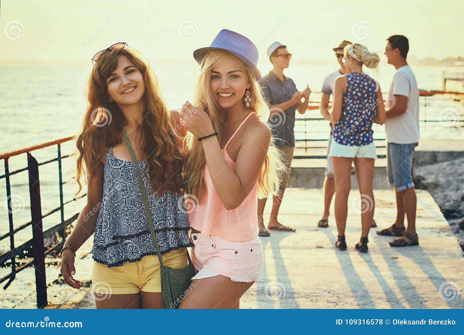 Due Belle Ragazze Che Si Divertono Alla Spiaggia Di Sera Con Il Gruppo ... Due Belle Ragazze Che Si Divertono Alla Spiaggia Di Sera Con Il Gruppo ...