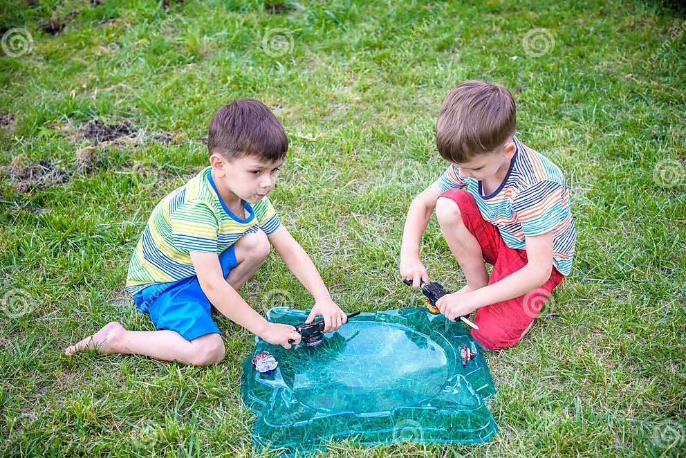 Due Ragazzi Che Giocano Con Un Giocattolo Del Bambino Della Trottola ... Due Ragazzi Che Giocano Con Un Giocattolo Del Bambino Della Trottola ...