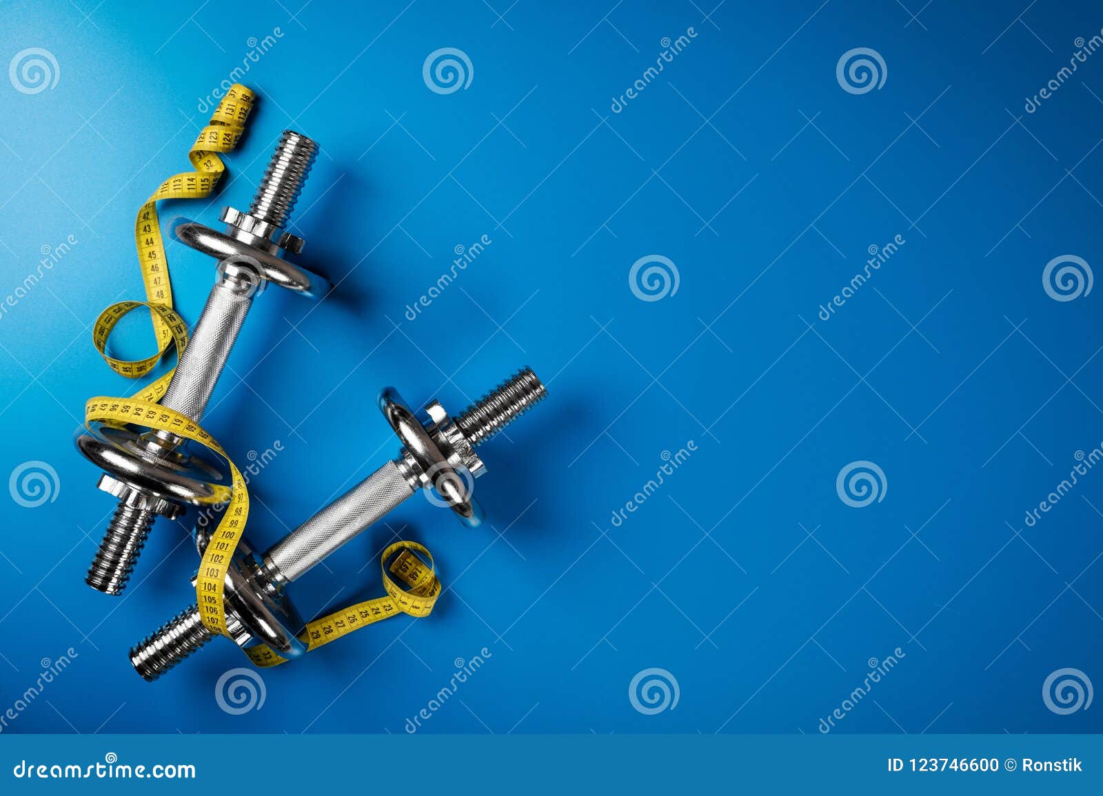 Dumbbells and Measuring Tape on Blue Background Stock Photo - Image of ...