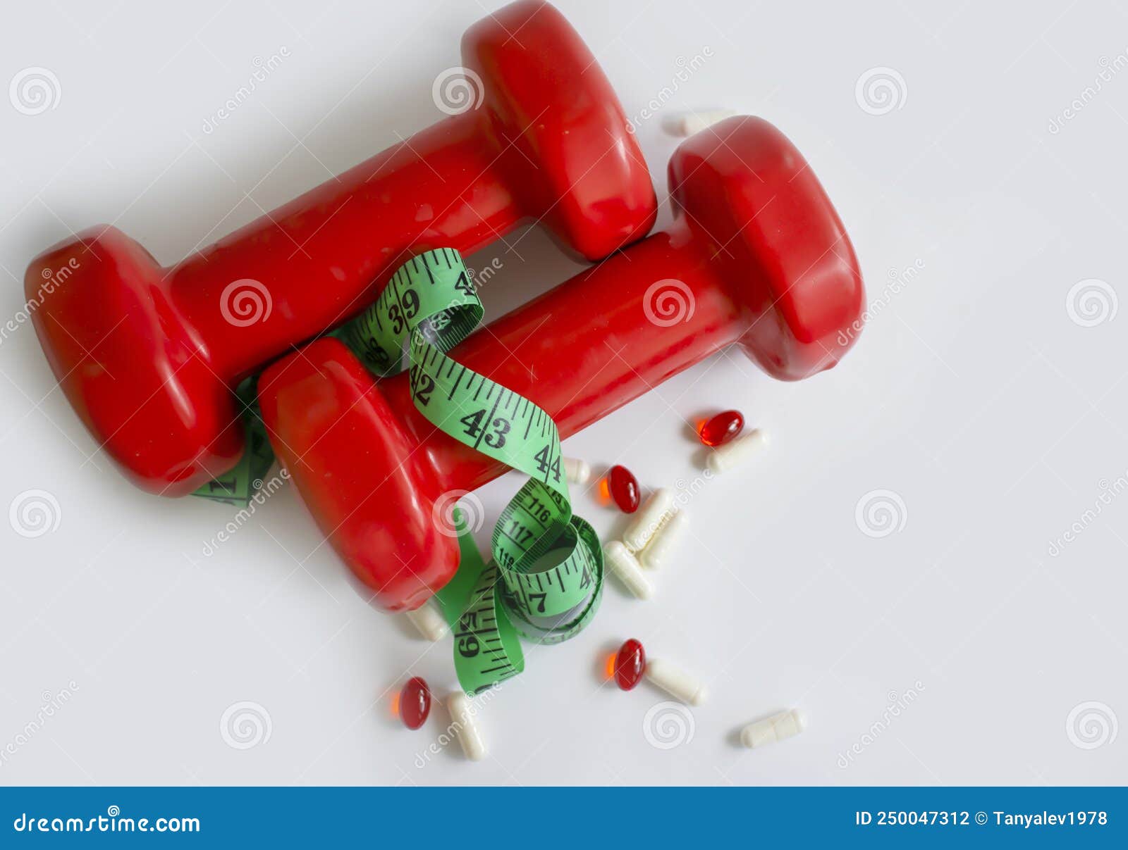 Dumbbells, Measuring Tape, Cure Capsules a Light Background Stock Photo ...