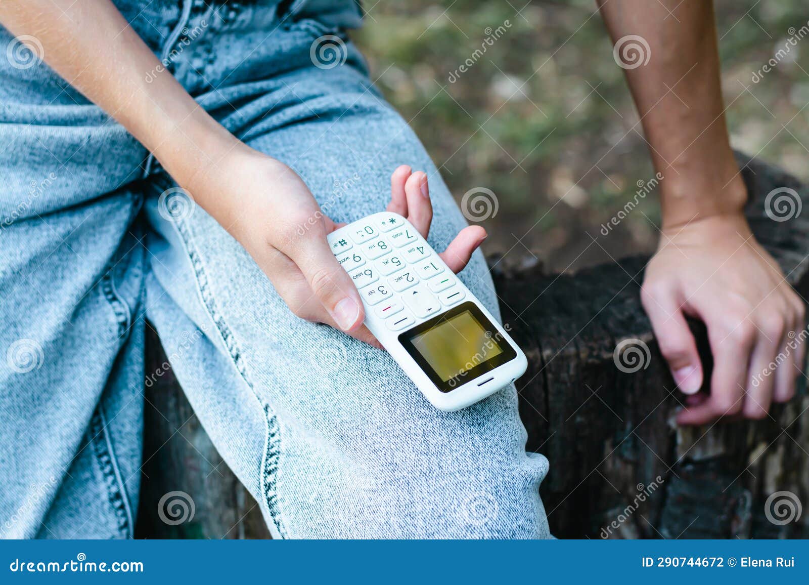 Dump Phone in the Hand of a Girl in Jeans on Her Knees Stock Photo ...