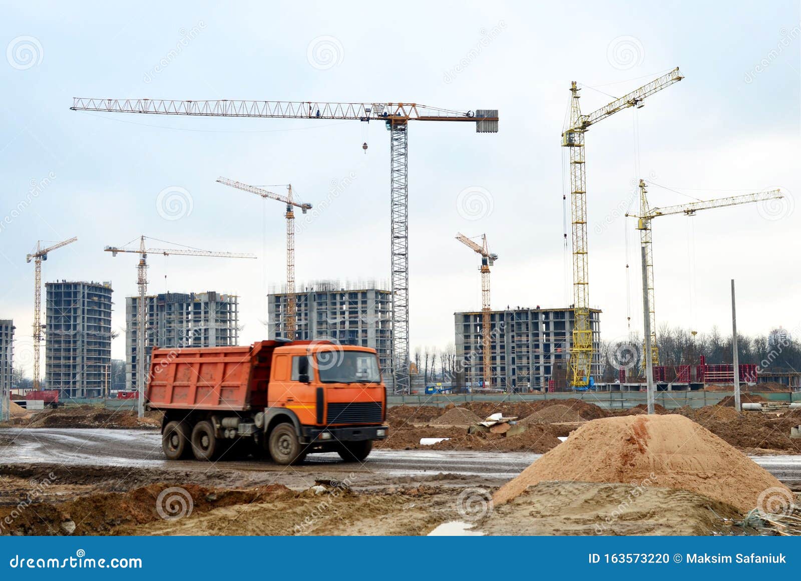 Dump Truck on the Construction Site Against Tower Cranes and ...