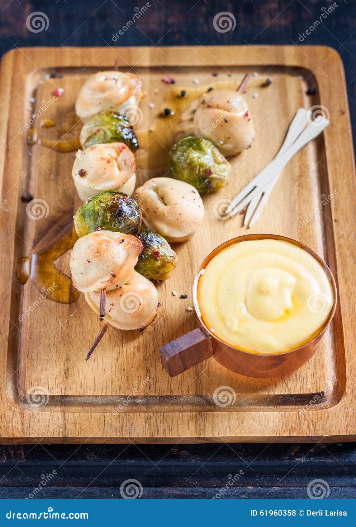 Dumplings and Brussels Sprouts on Skewers with Cheese Sauce Stock Photo ...