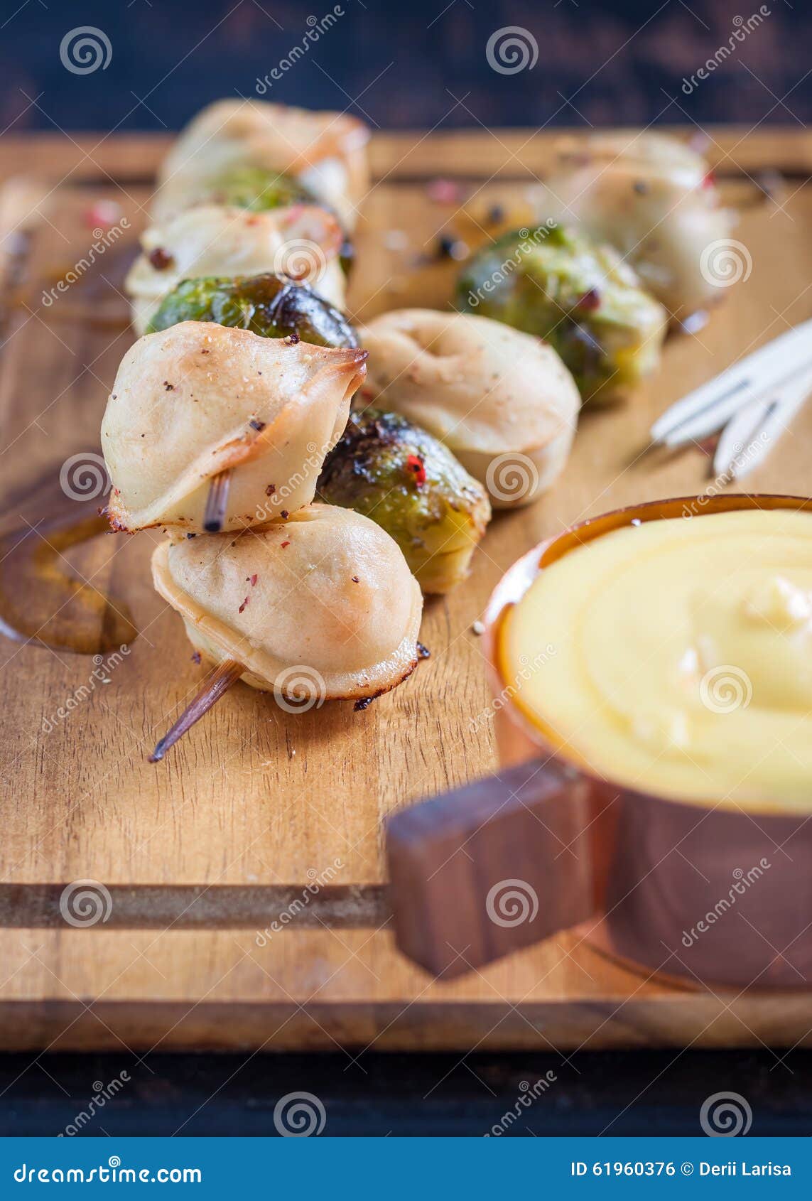 Dumplings and Brussels Sprouts on Skewers with Cheese Sauce Stock Photo ...