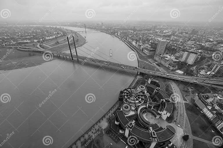 Dusseldorf Cityscape with Bridge and River Under Cloudy Skies, Captured ... Dusseldorf Cityscape with Bridge and River Under Cloudy Skies, Captured ...