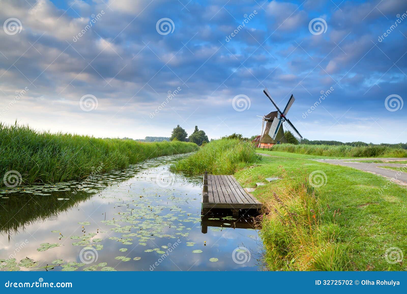 Dutch Windmill by River with Reflected Blue Sky Stock Photo - Image of ...