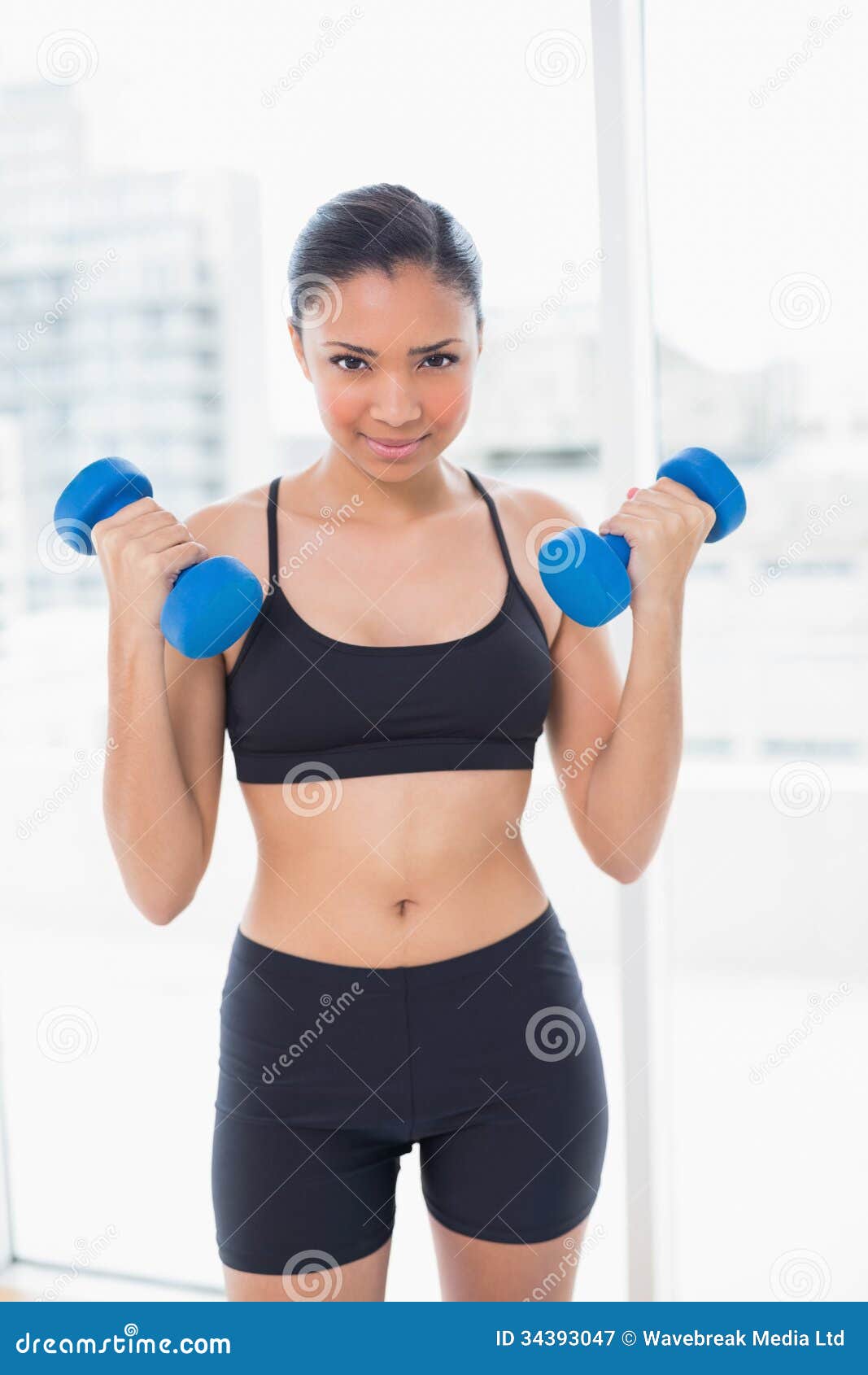 Dynamic Dark Haired Model In Sportswear Exercising With Dumbbells Stock