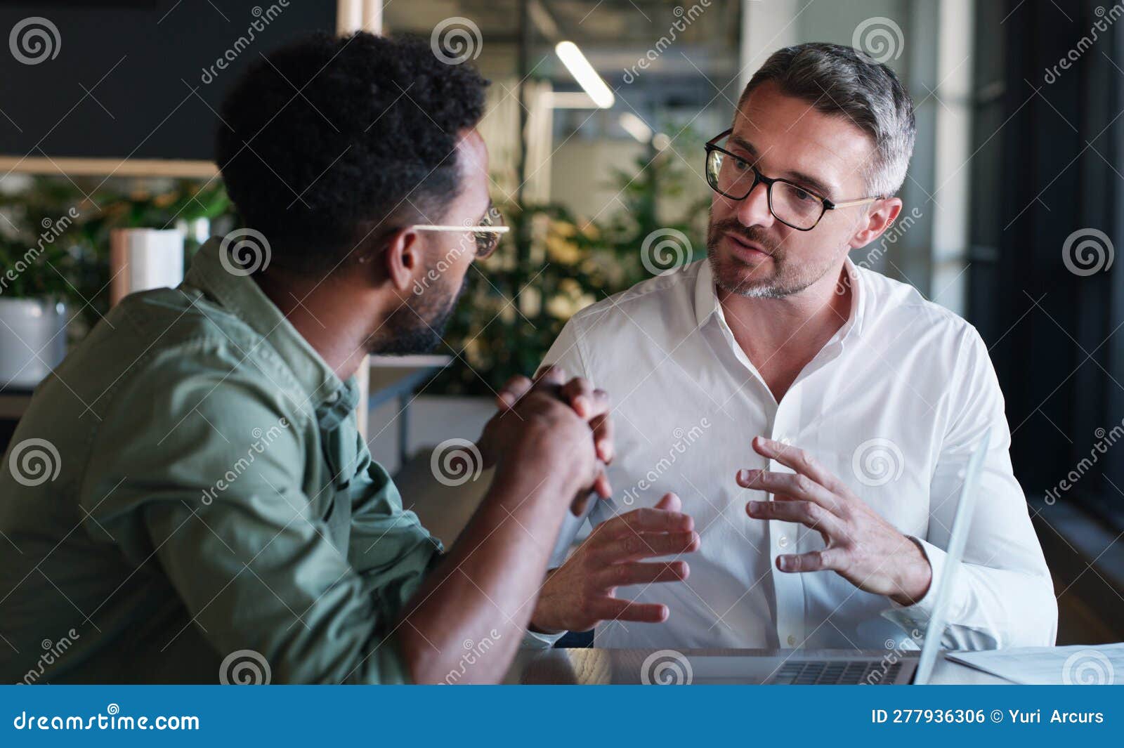 A Dynamic Duo that Gets Things Done. Two Businessmen Using a Laptop and ...