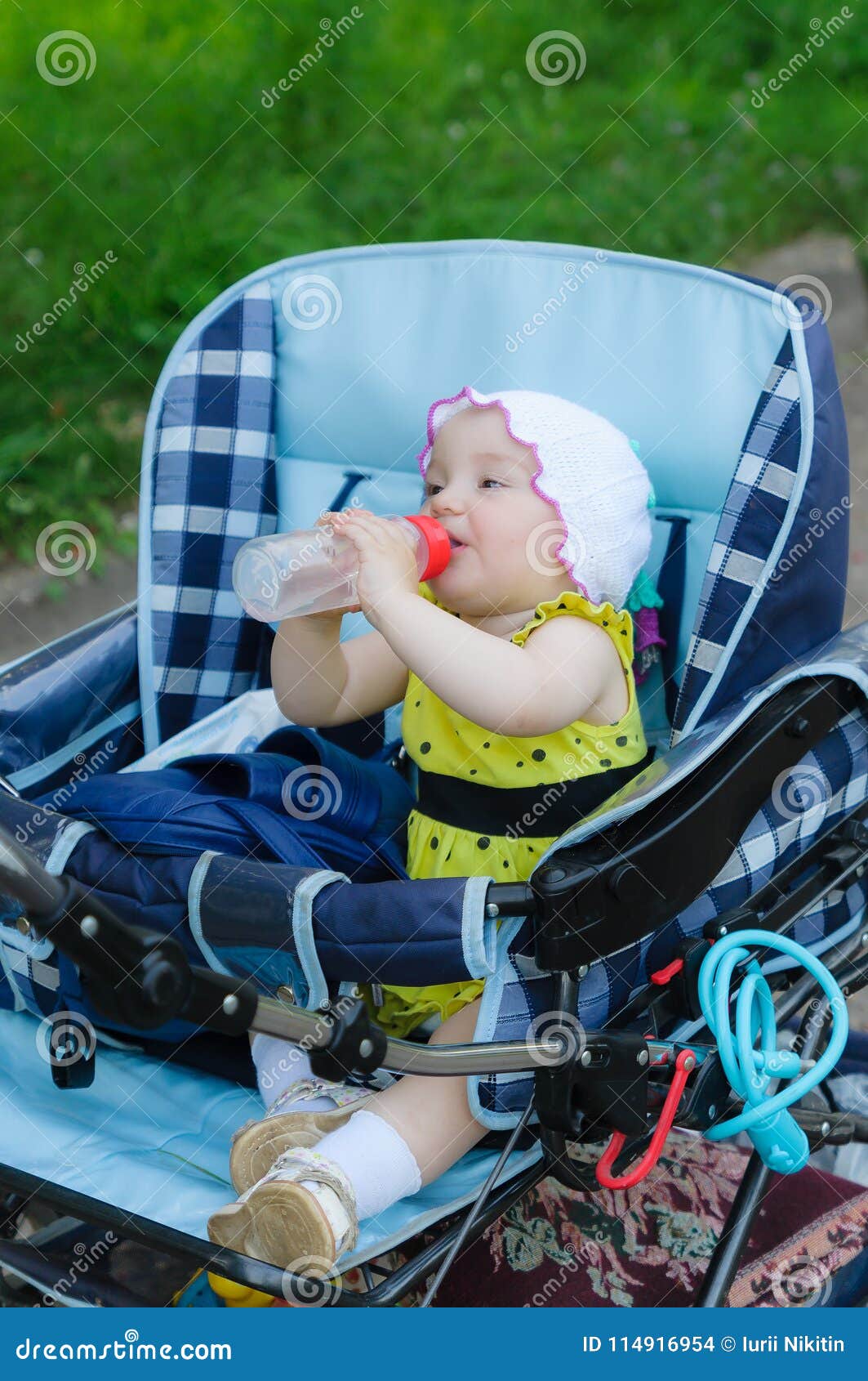 The Child Sits in a Stroller and Drinks Water Fotografia Stock ...