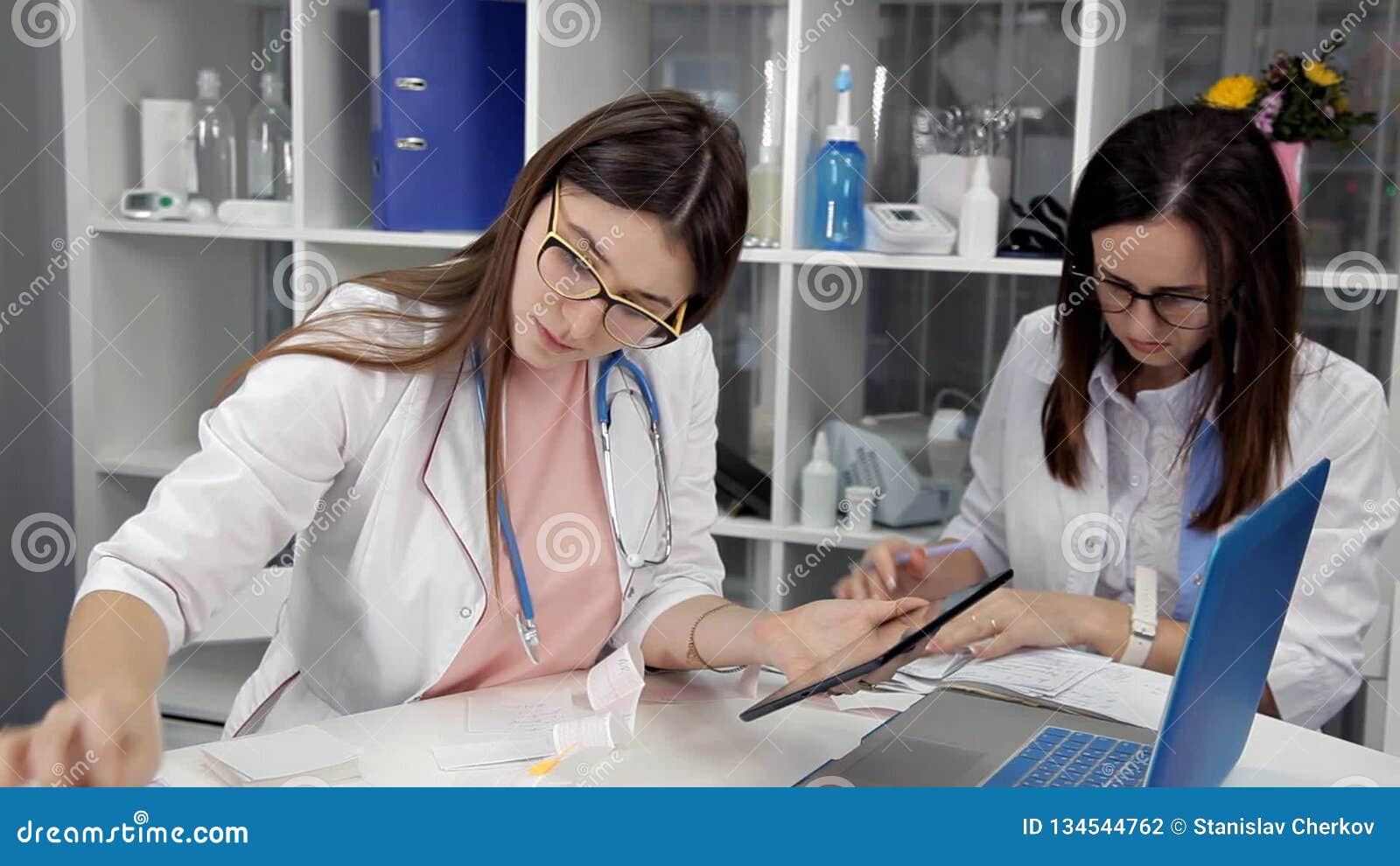 Women Doctors Work at the Table in the Office with a Laptop and Tablet ...