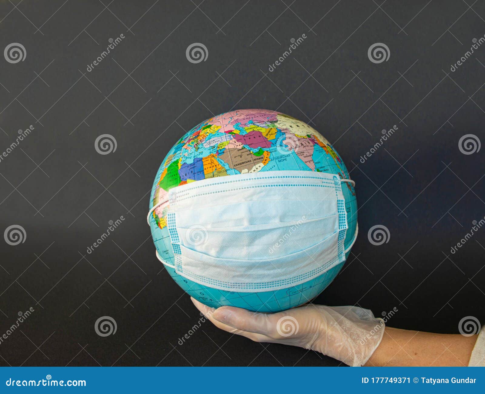 Earth Globe Dressed in a Protective Mask on the Hands of a Man in ...