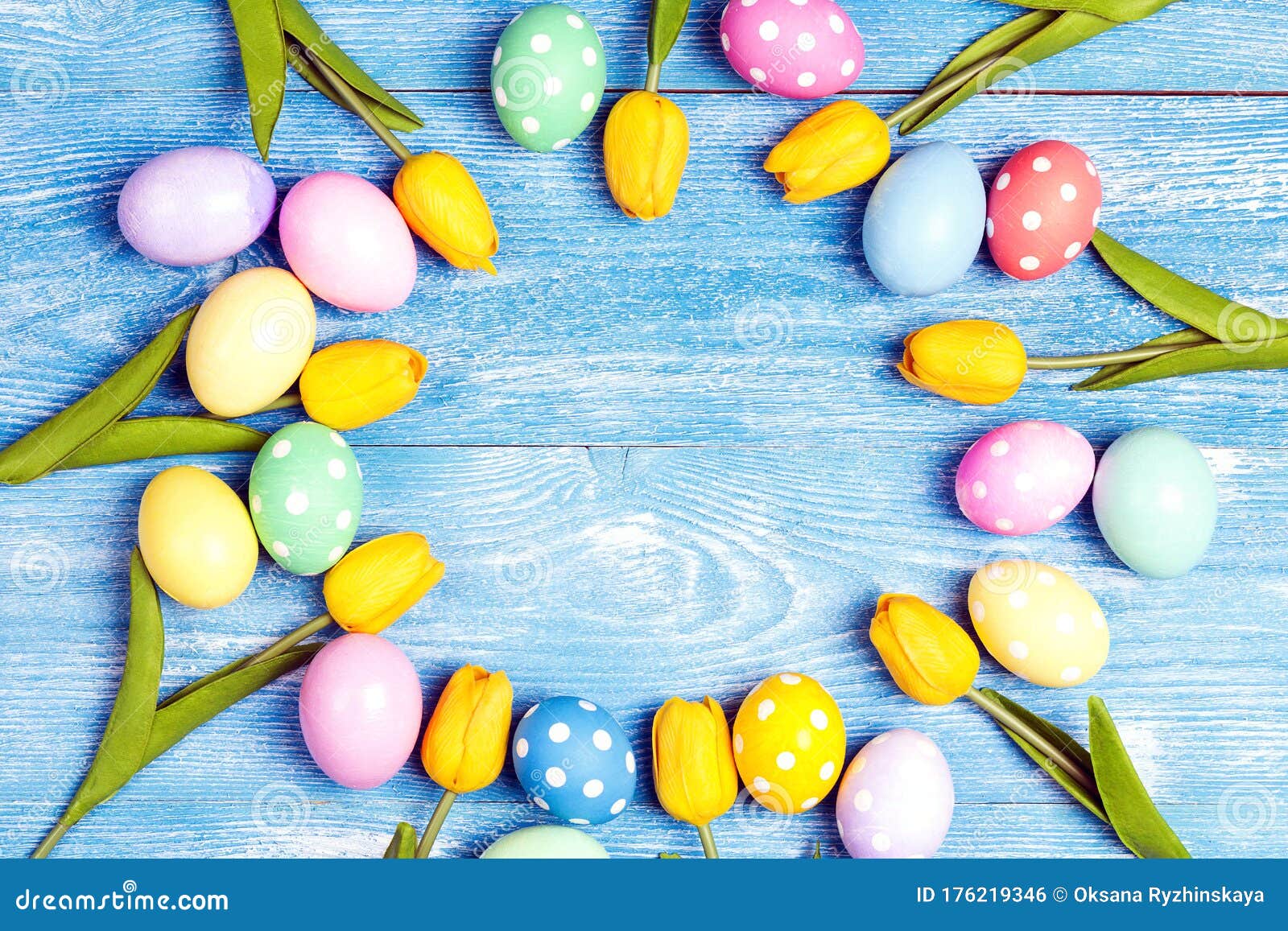 Easter Round Frame from Colored Eggs and Yellow Tulips on Blue Wooden ...