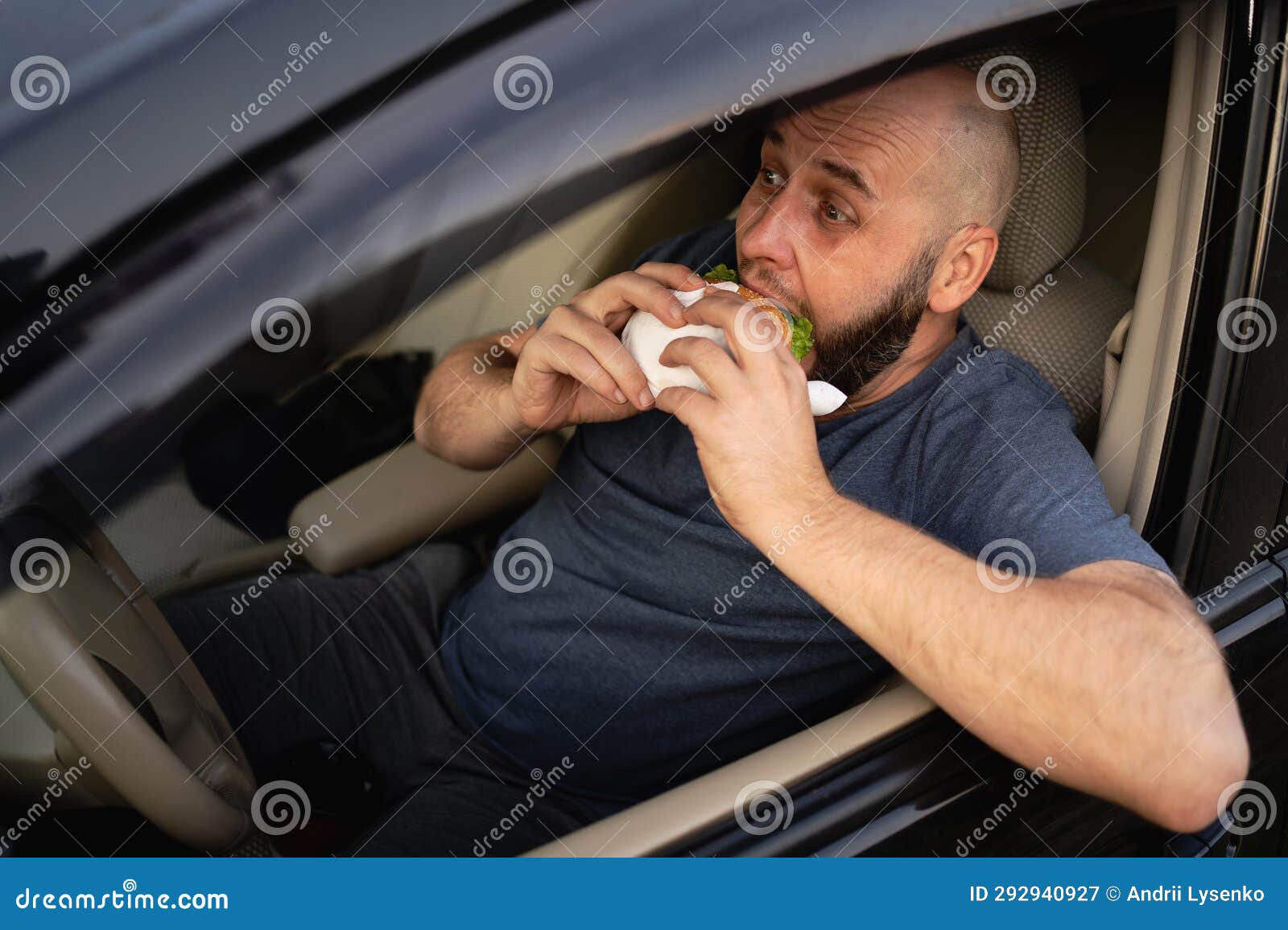 Eat in the Car. Man Eating Hamburger while Driving Car Stock Image ...