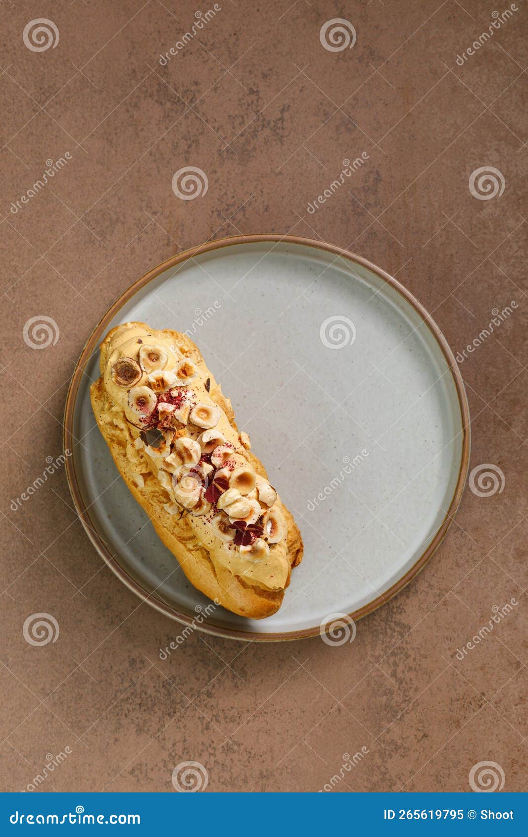 Eclair Served with Fried Hazelnuts on Plate. Stock Image - Image of ...