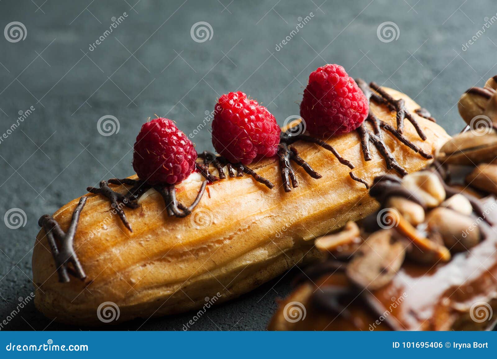 Eclairs with Peanuts, Chocolate Icing and Raspberries Stock Photo ...