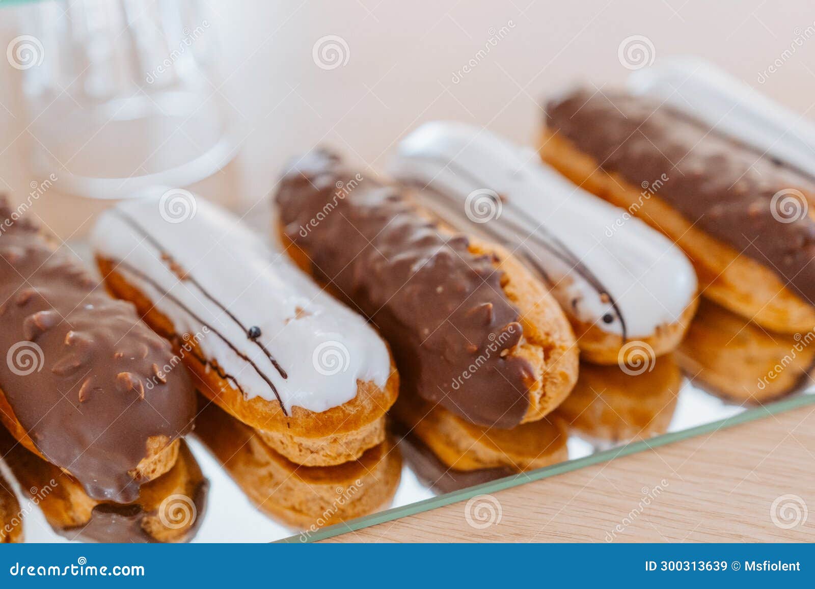 Eclairs with White and Chocolate Icing are Laid Out in a Row on a ...
