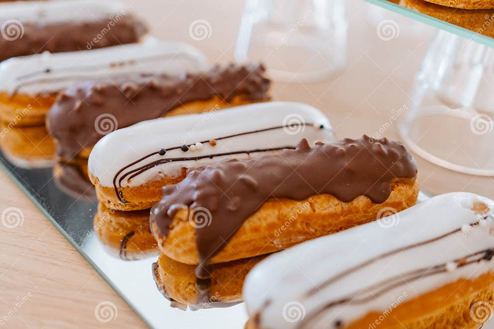 Eclairs with White and Chocolate Icing are Laid Out in a Row on a ...