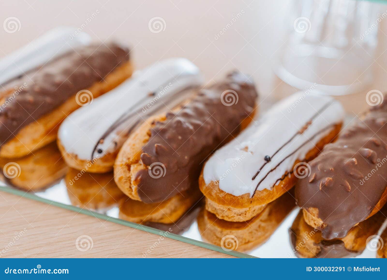Eclairs with White and Chocolate Icing are Laid Out in a Row on a ...