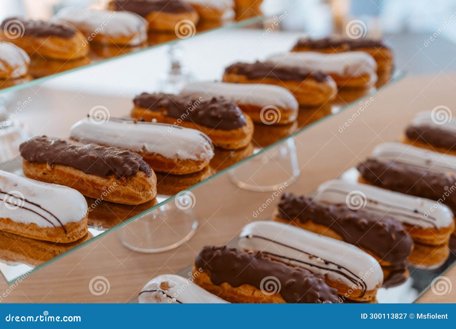 Eclairs with White and Chocolate Icing are Laid Out in a Row on a ...
