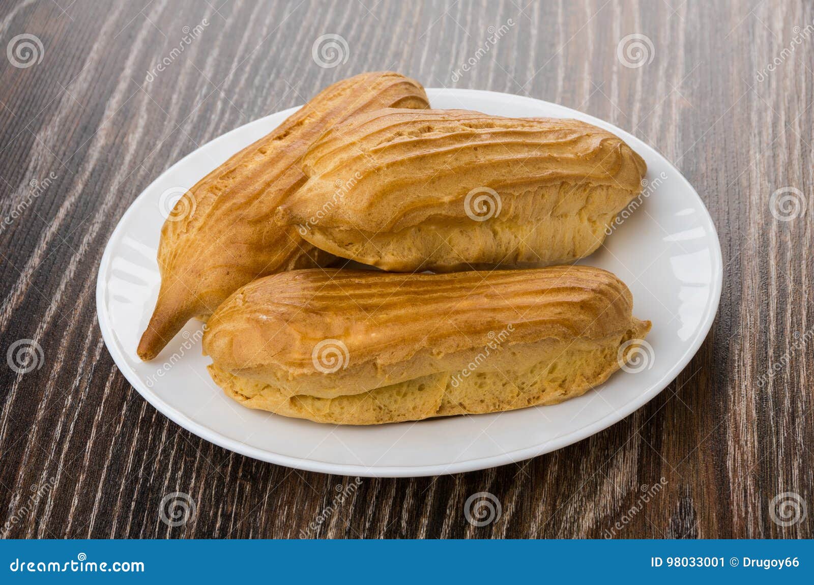 Eclairs in White Plate on Dark Table Stock Image - Image of closeup ...