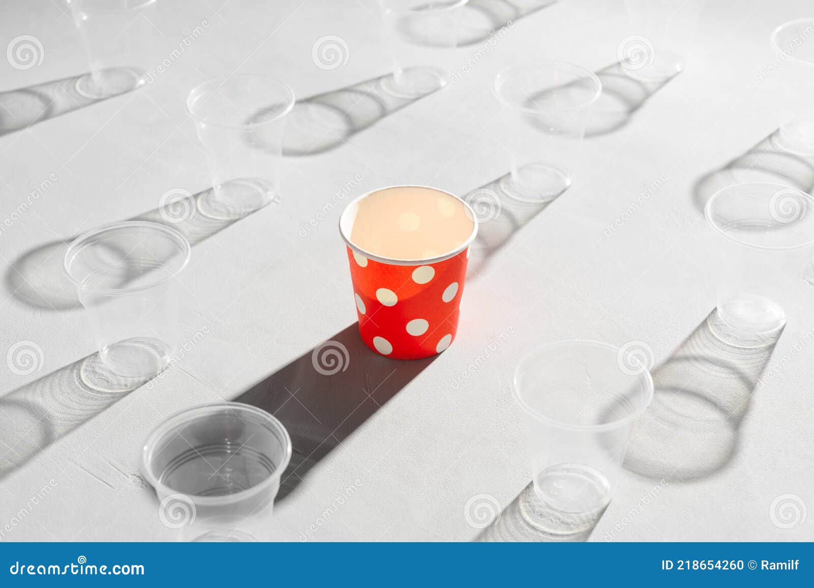 Eco Friendly Red Paper Cup Surrounded by Plastic Cups on a Gray Table ...