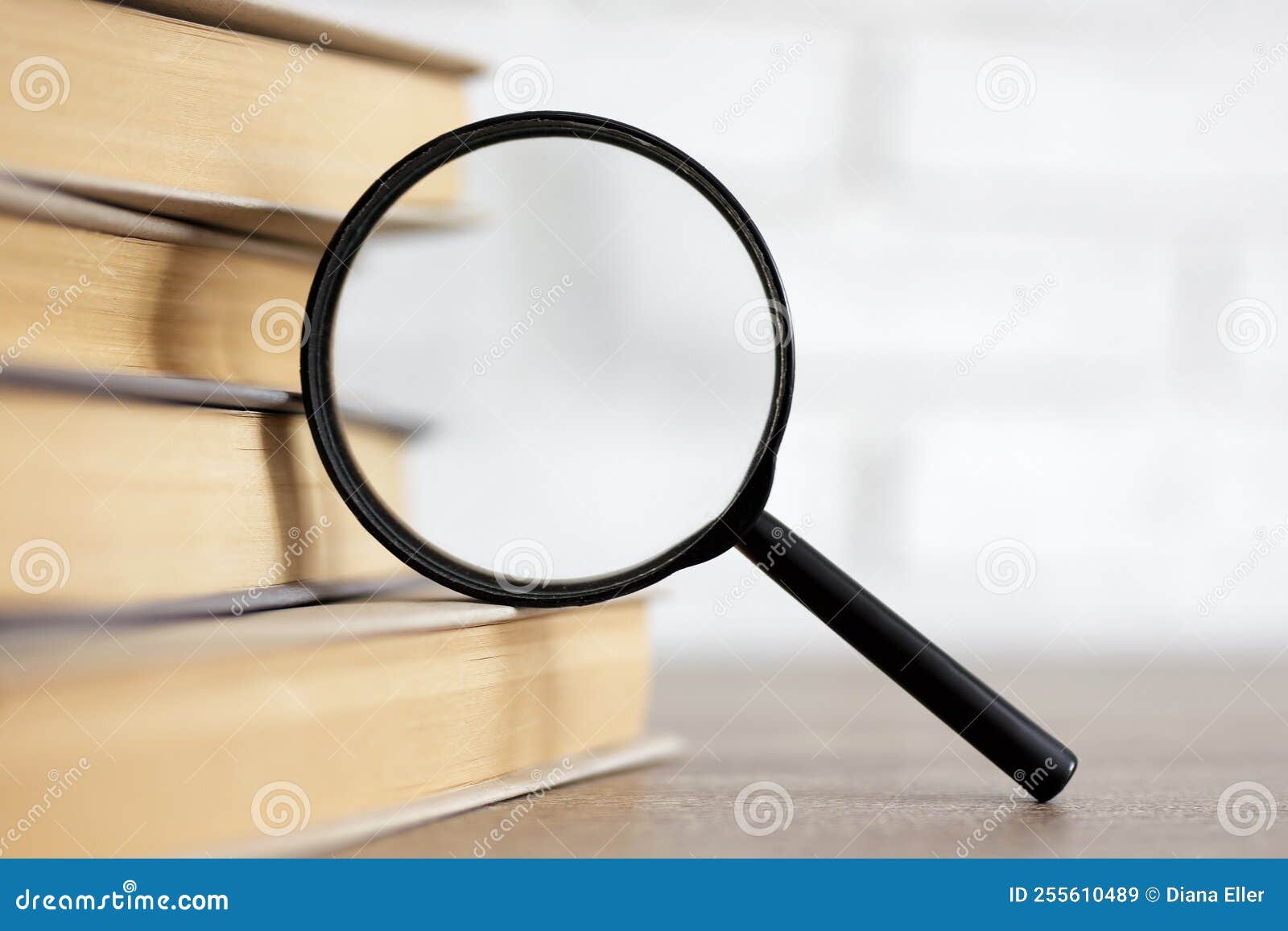 Education and Research Concept - Stack of Books and Magnifying Glass on ...