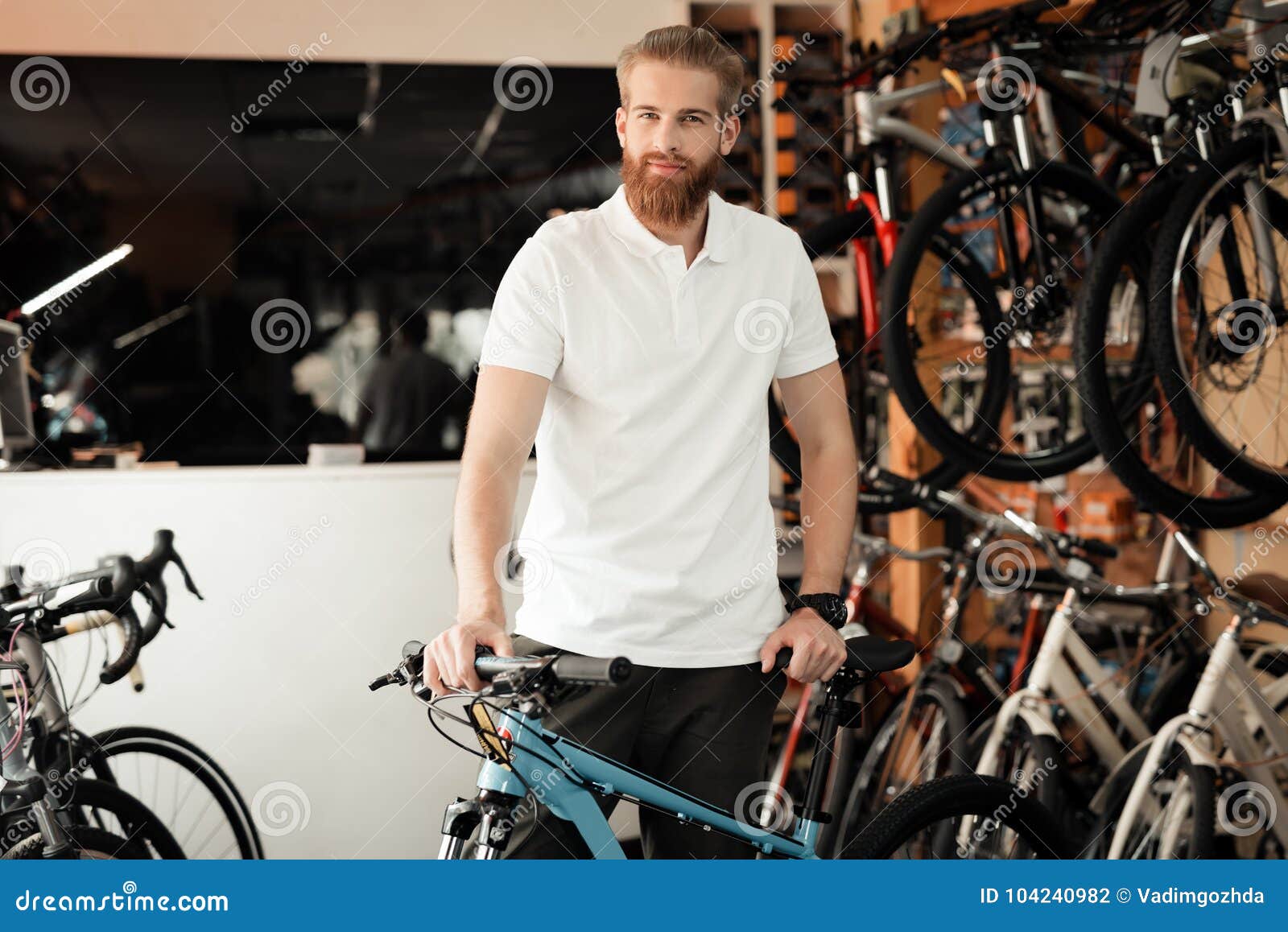 Een Verkoper in Een Fietswinkel Stelt Dichtbij Een Fiets Stock Foto ...