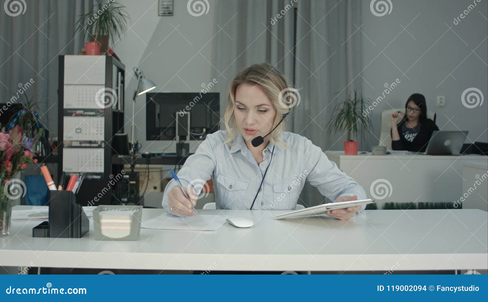 Efficient Call Operator Making Notes and Using Tablet while Talking ...