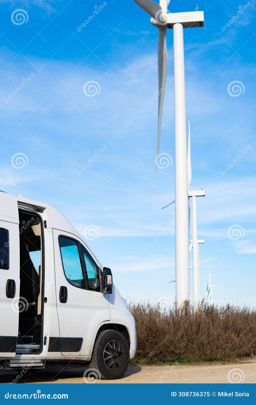 Efficient Mobile Workstation: White Van Parked by Wind Turbines in ...