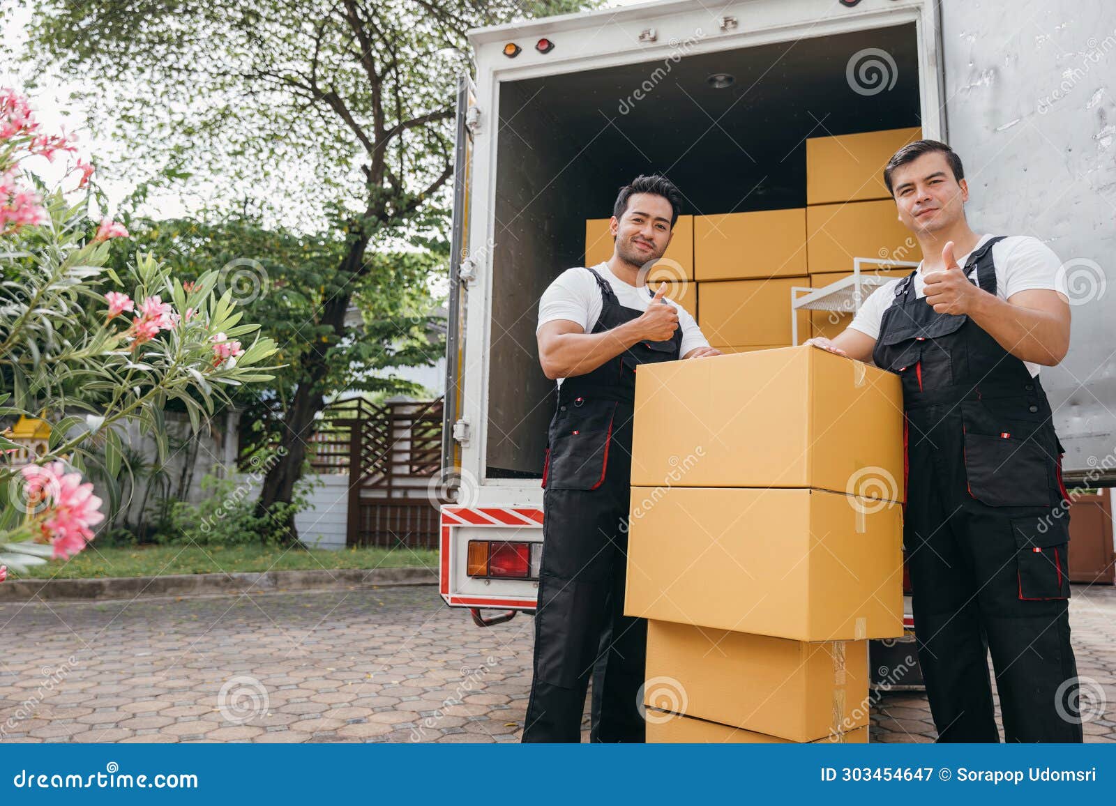 Employees Work Together Unloading Cardboard Boxes from the Truck for a ...
