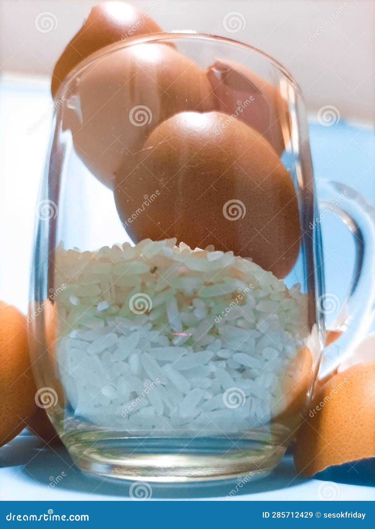 Egg Shells and Raw Rice in a Transparent Glass on a Blue Background ...