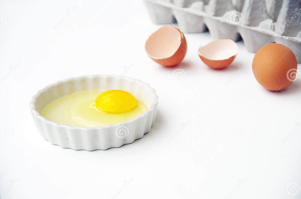 Egg Yoke with Egg Shells and Egg Carton in White Background Stock Photo ...