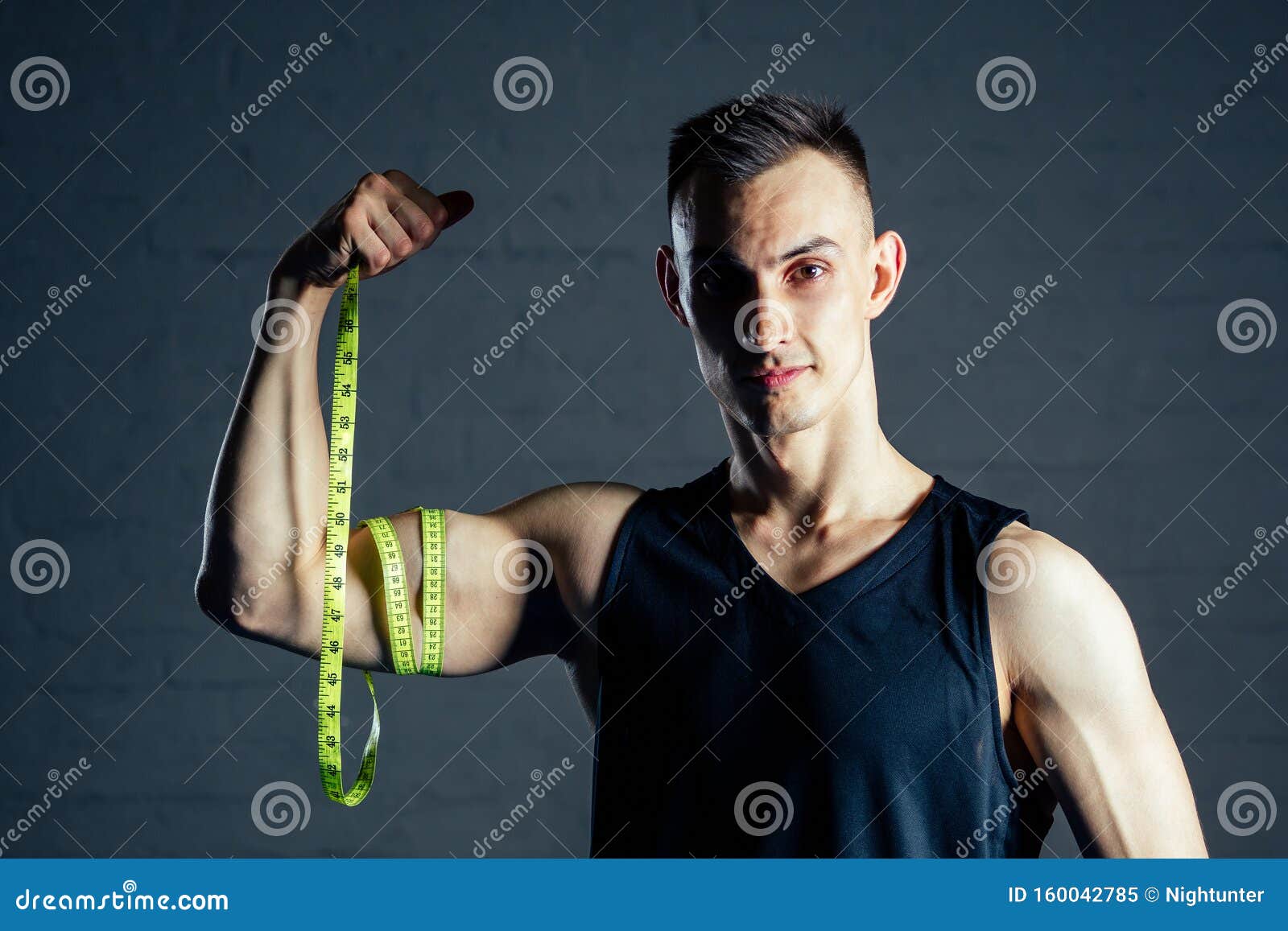 Ein Junger Mann Misst Seine Hand Mit Einem Messband Im Fitnessraum ... Ein Junger Mann Misst Seine Hand Mit Einem Messband Im Fitnessraum ...