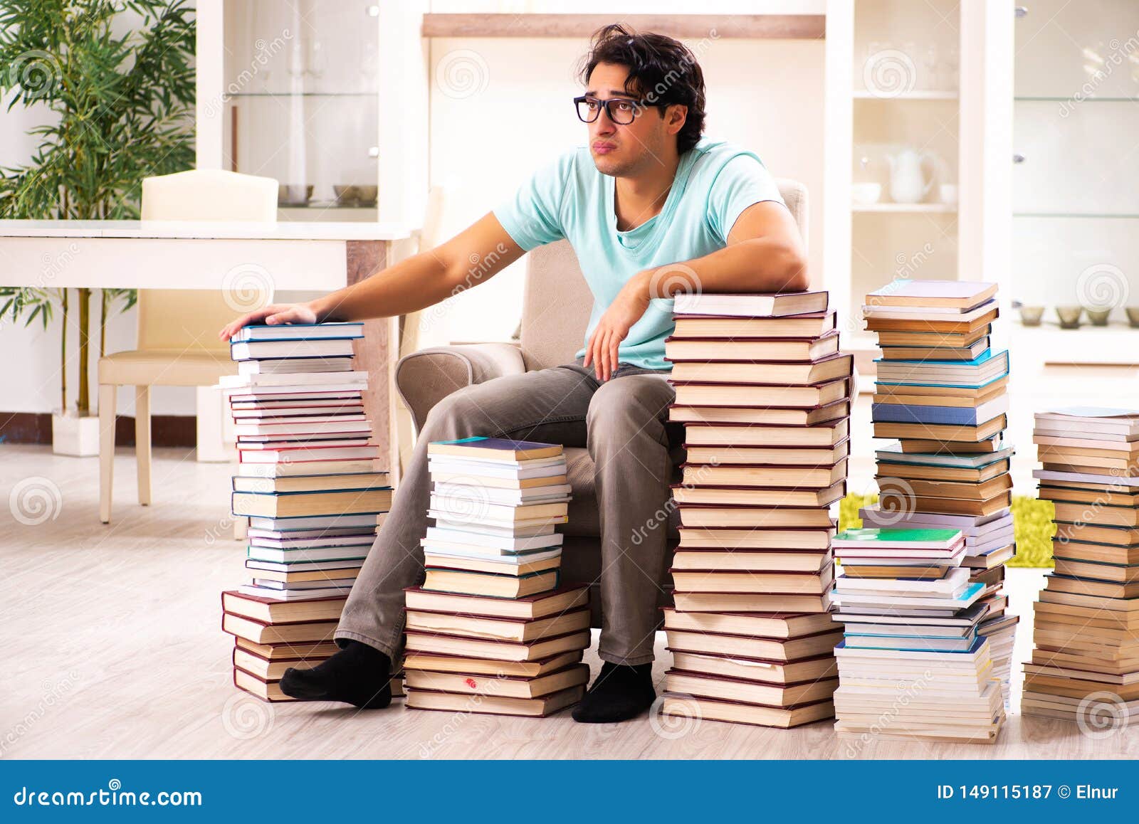 El Estudiante Masculino Con Muchos Libros En Casa Imagen de archivo ...