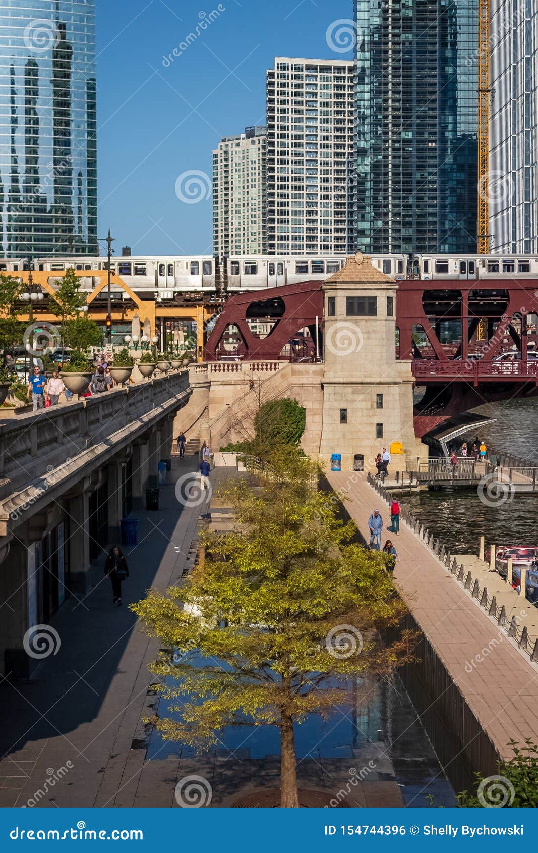 El Train Crossing Chicago River while Commuters Walk Riverwalk ...