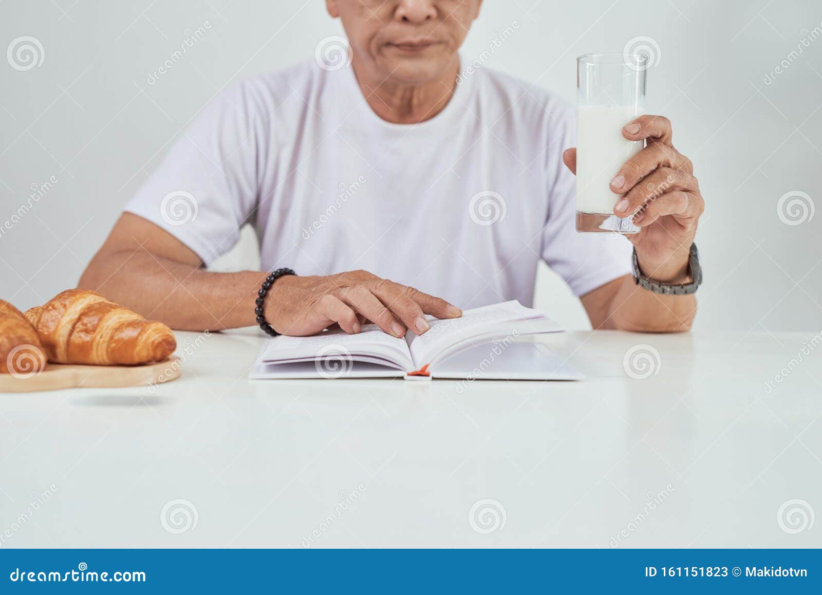Elder Man Drinking Milk and Reading Book while Having Breakfast Stock ...