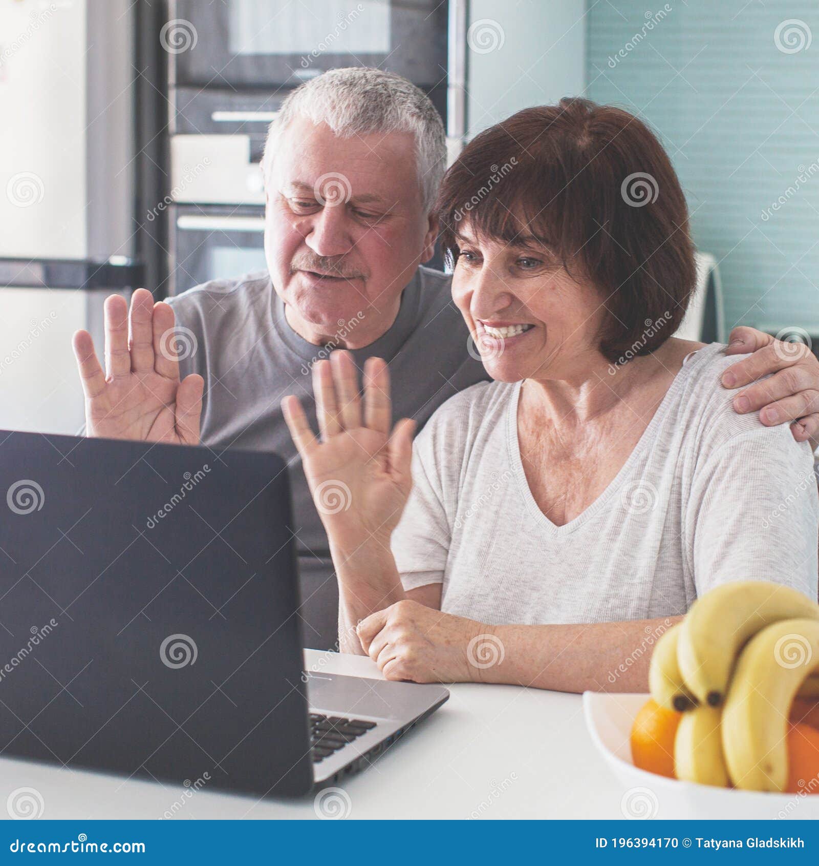 Elderly Couple Looking at Computer in the Kitchen Stock Photo - Image ...