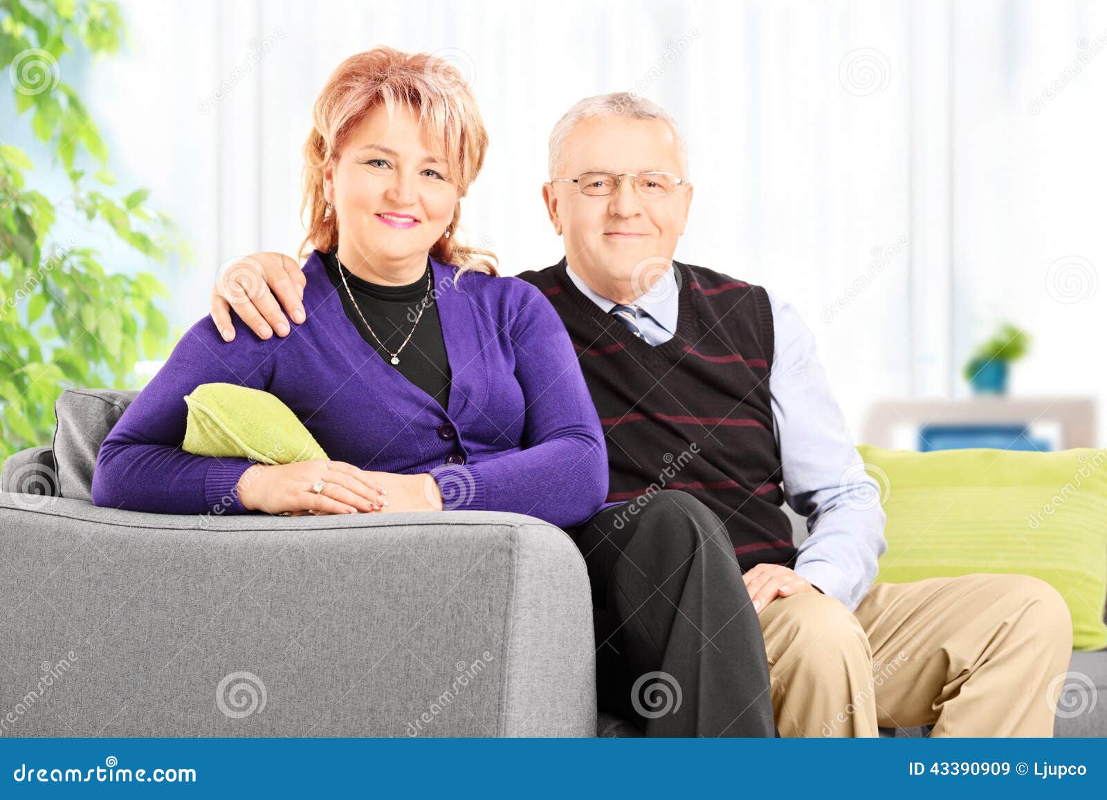 Elderly Couple Posing Seated on a Sofa at Home Stock Image - Image of ...