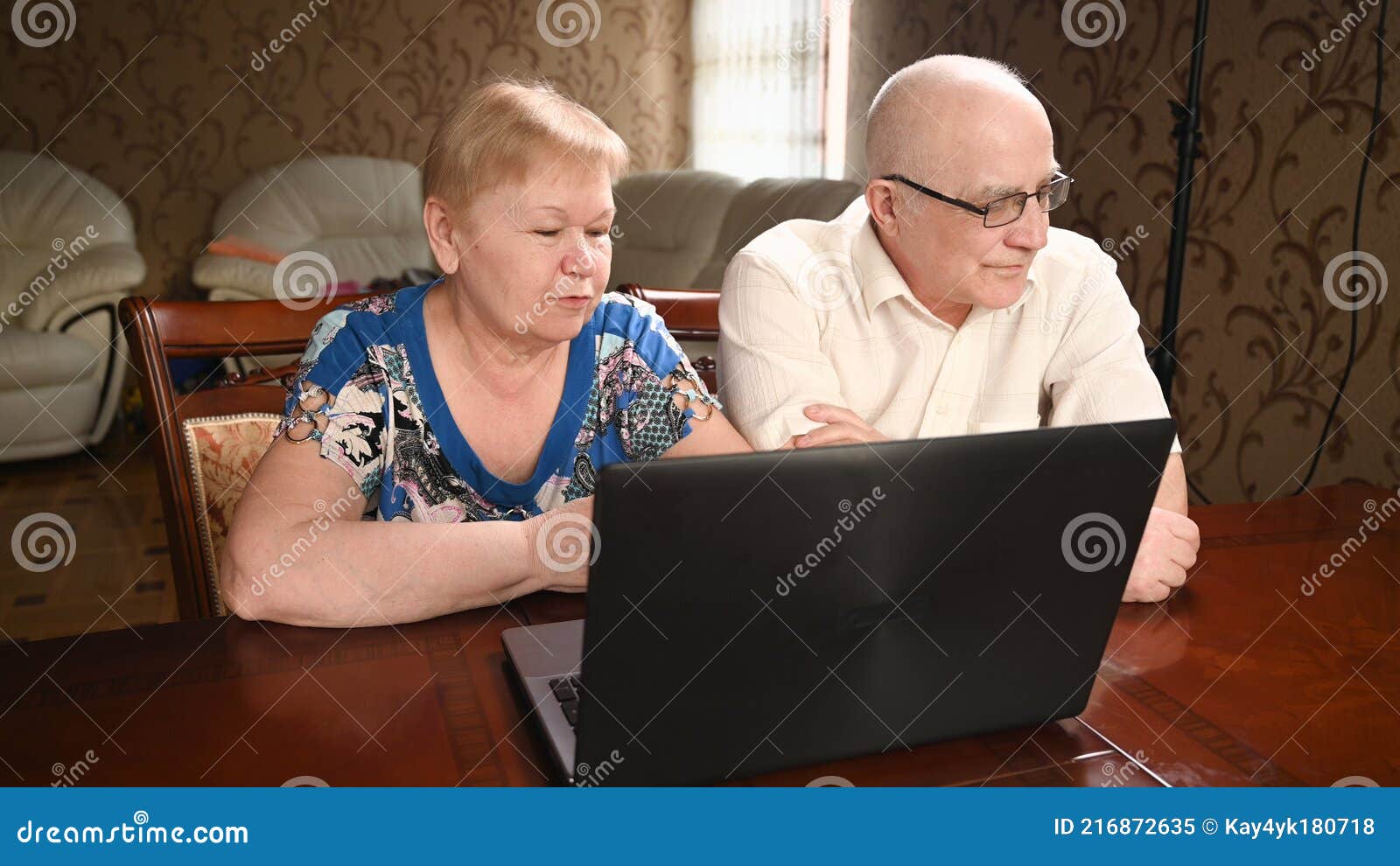 An Elderly Couple is Sitting at a Computer Looking for Information on ...