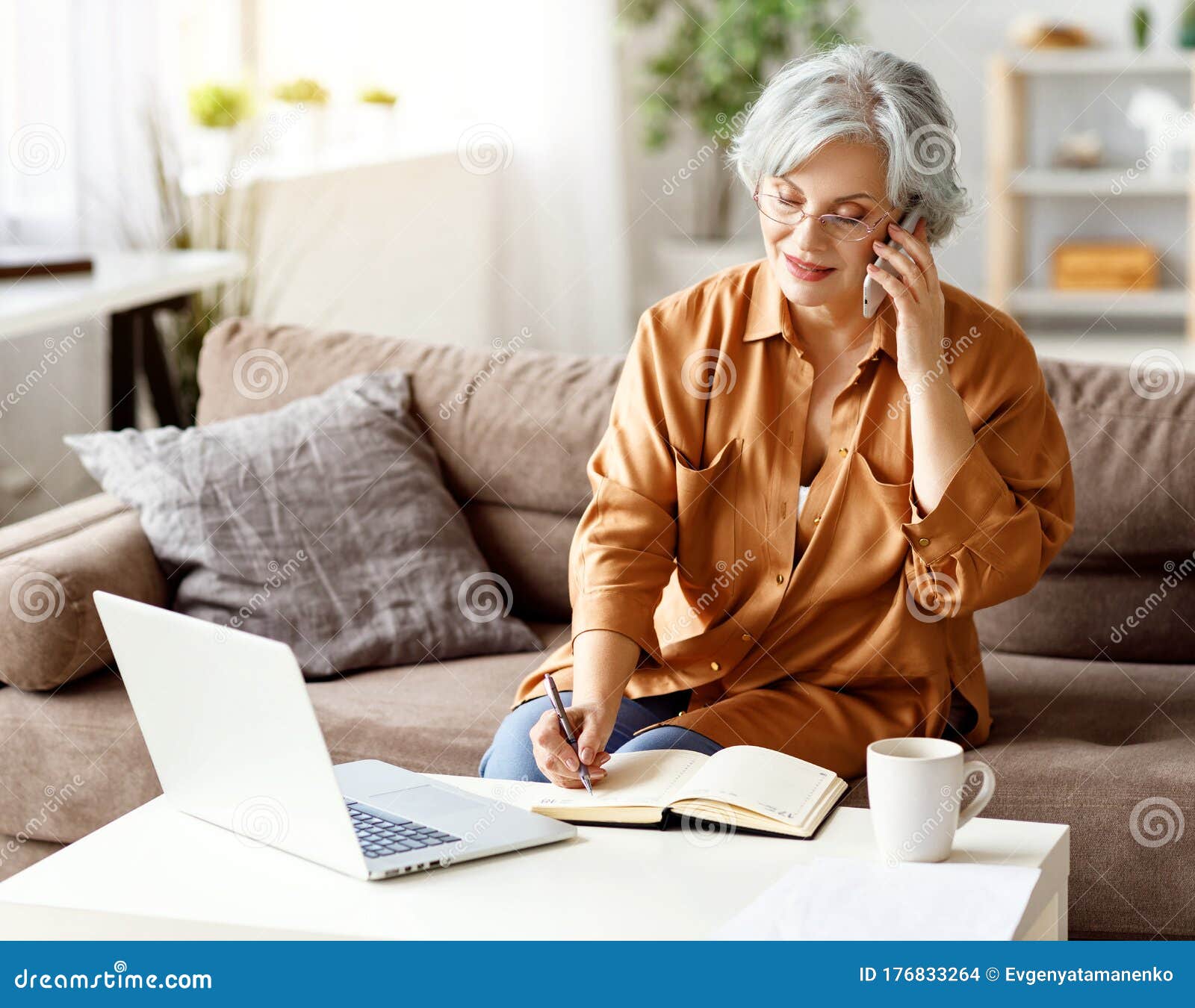 Elderly Freelancer Speaking on Phone and Making Notes Stock Photo ...