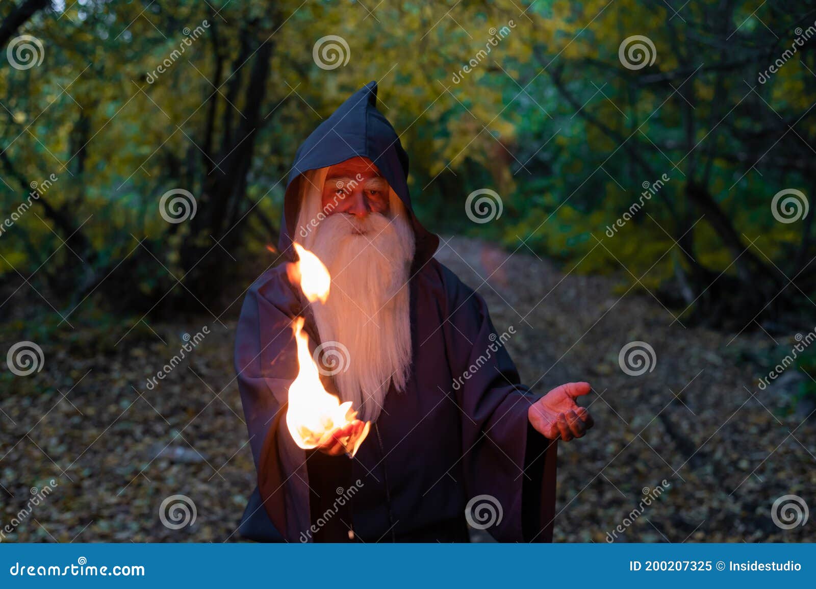 An Elderly Gray-haired Witcher Casts a Fire Spell in the Forest. Man in ...