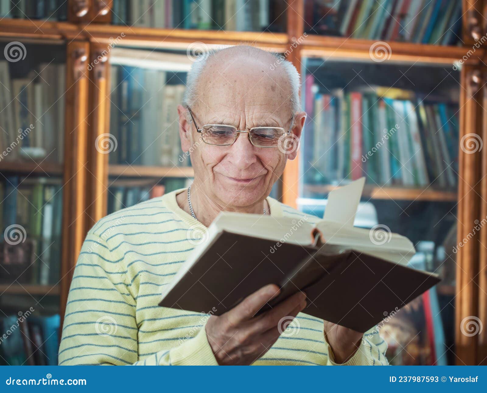 Elderly Intelligent Man Reading Book in His Library at Home in ...