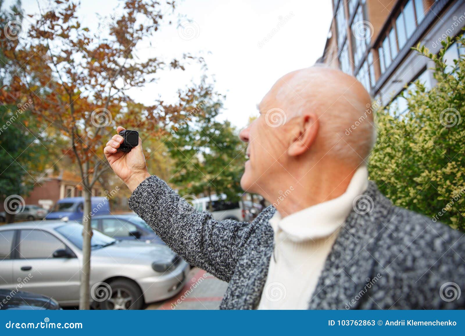 An Elderly Man with a Mini Camera in His Hands, Back View. Stock Image ...