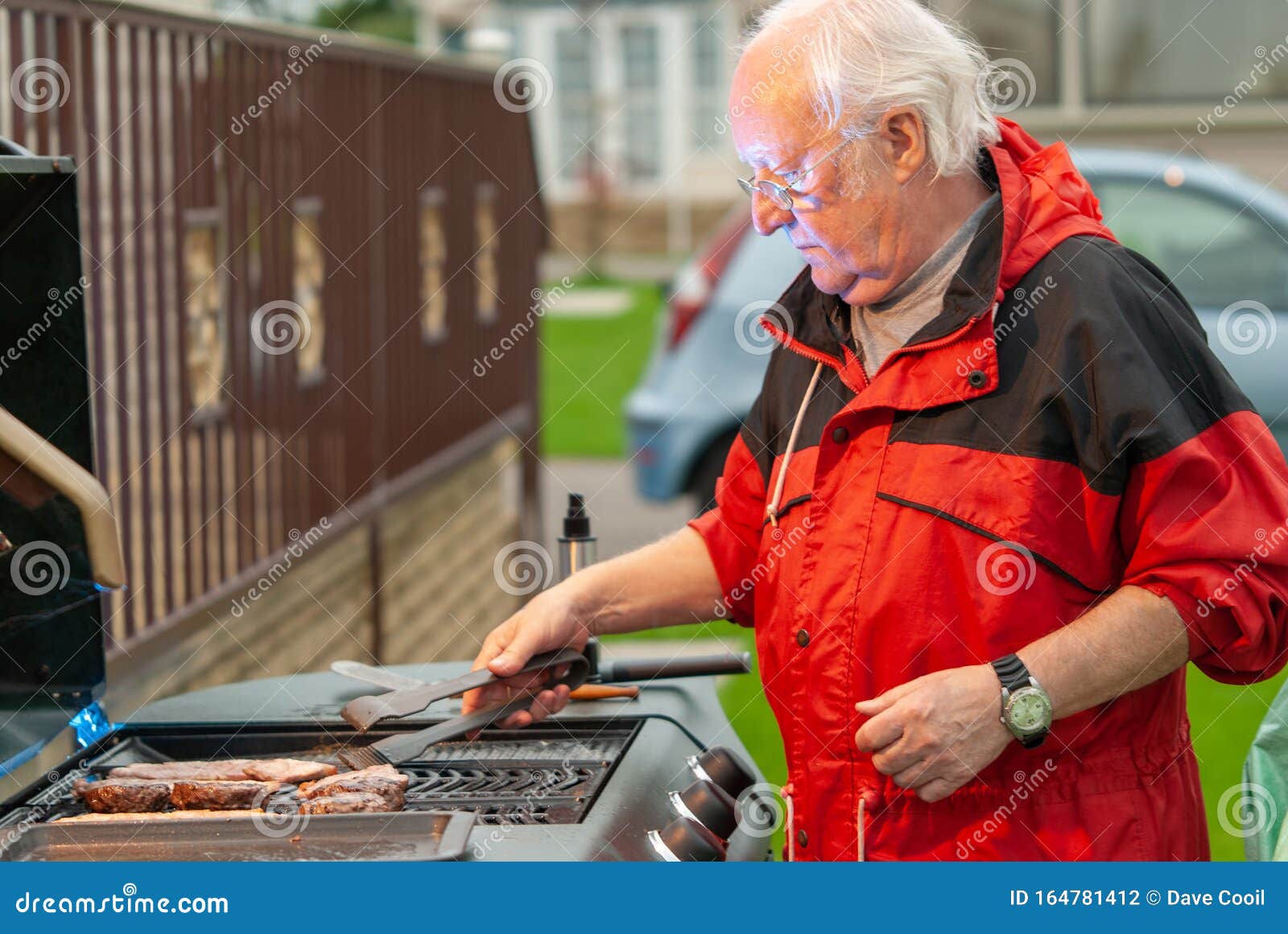 Elderly Man in a Red Coat Cooking Meat on a BBQ Stock Photo - Image of ...