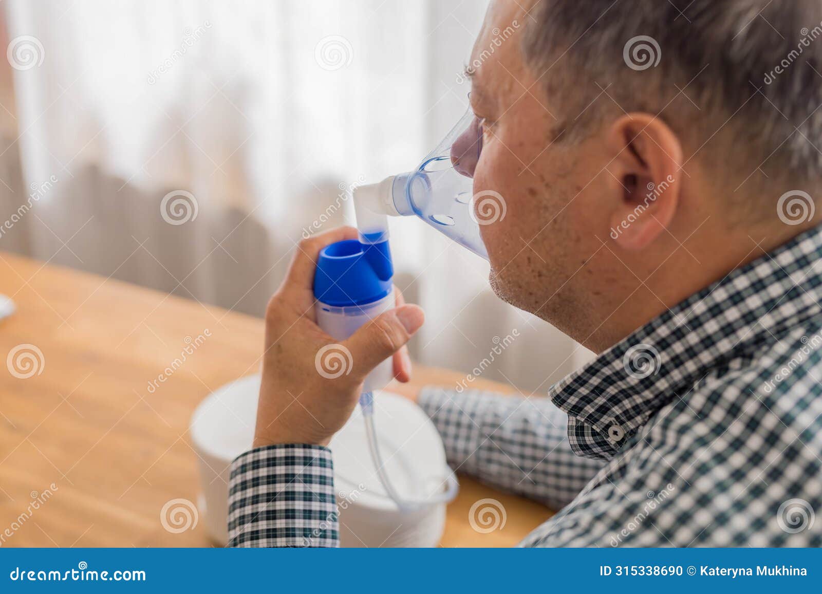 Elderly Man Sitting on a Table and Using a Nebulizer Mist at Home Stock ...