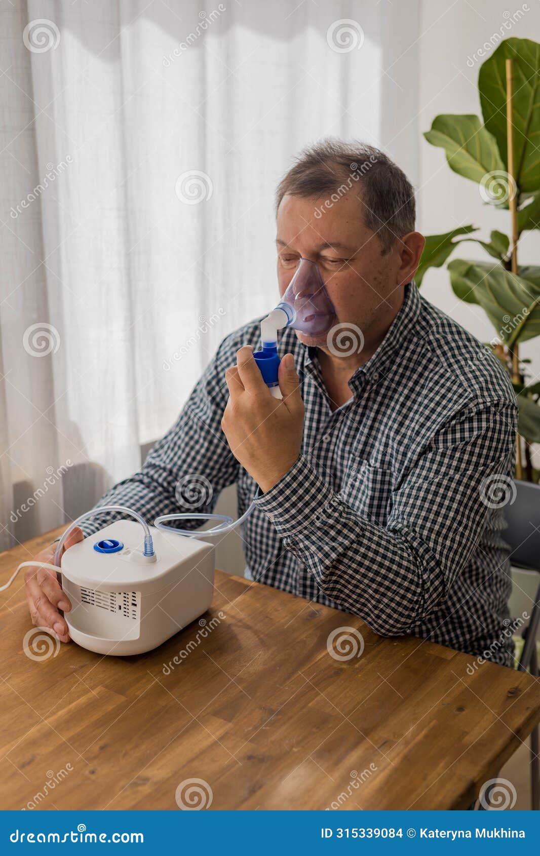 Elderly Man Sitting on a Table and Using a Nebulizer Mist at Home Stock ...